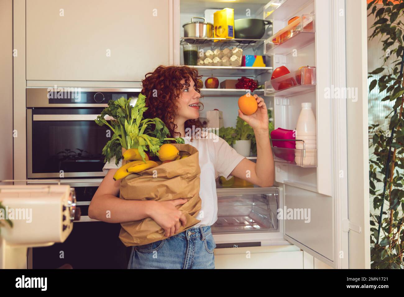 Ginger girl unpacking food in the kitchen Stock Photo - Alamy