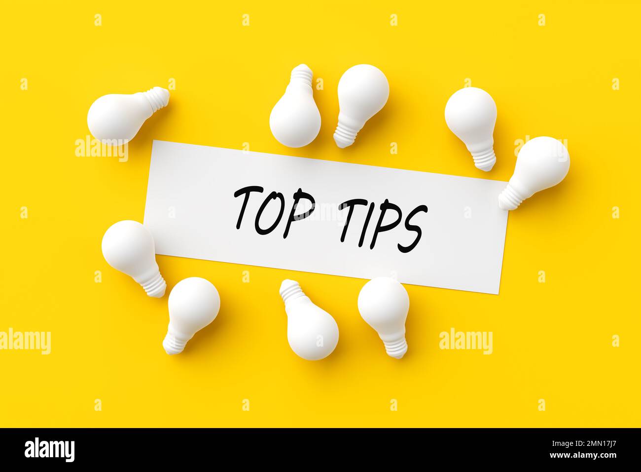 The word top tips on white paper surrounded with light bulbs. Useful ...