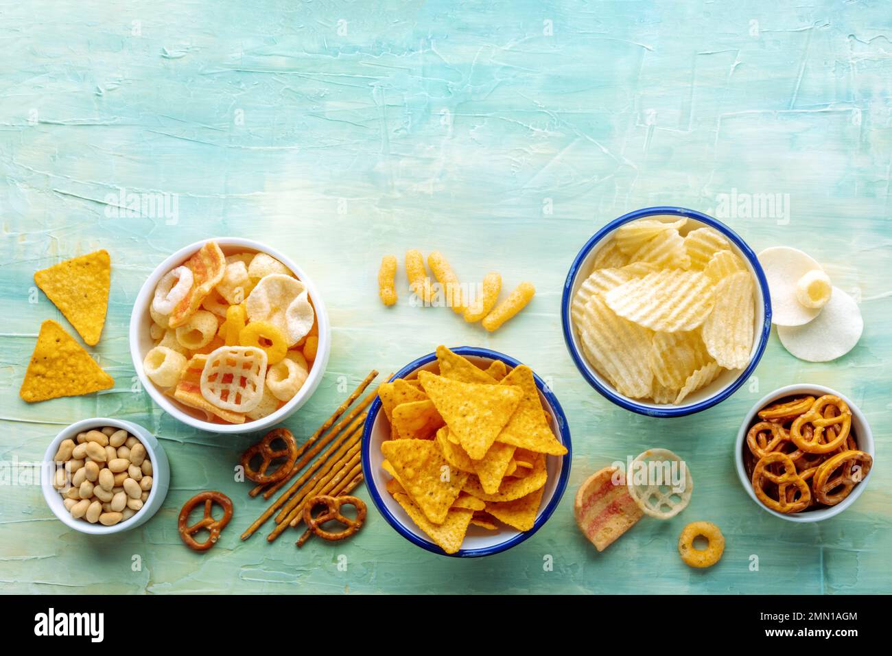 Salty snacks with a place for text. Party food. Potato chips, nachos ...