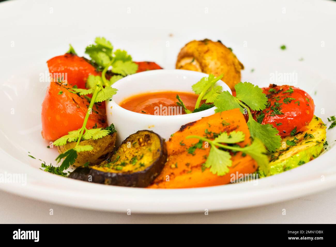 Food in a restaurant on a white plate. A man eats with a fork grilled ...