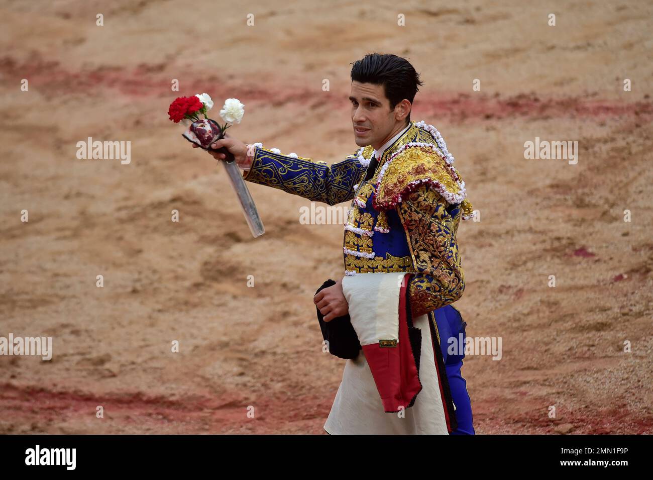 Spanish bullfighter Lopez Simon holds on his hand flowers and a ear of ...