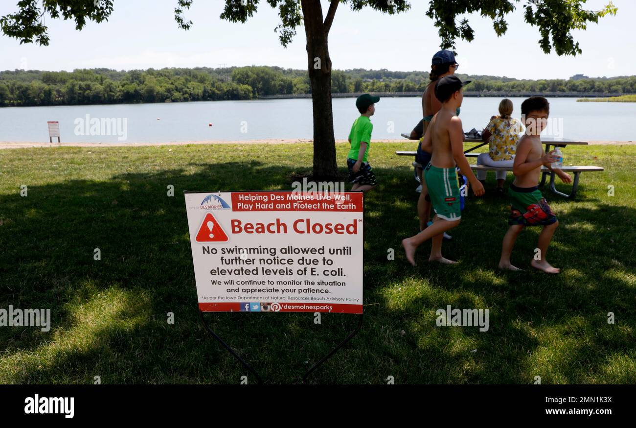 A beach closed sign is posted at the Gray's Lake Park beach warning of ...