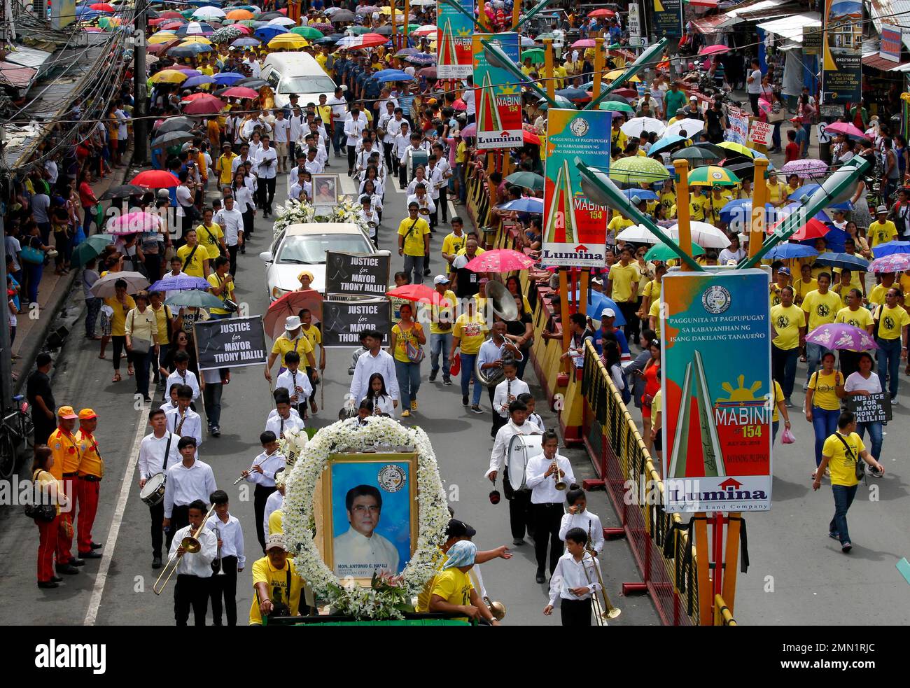 Thousands of residents follow the hearse bearing the coffin of slain ...