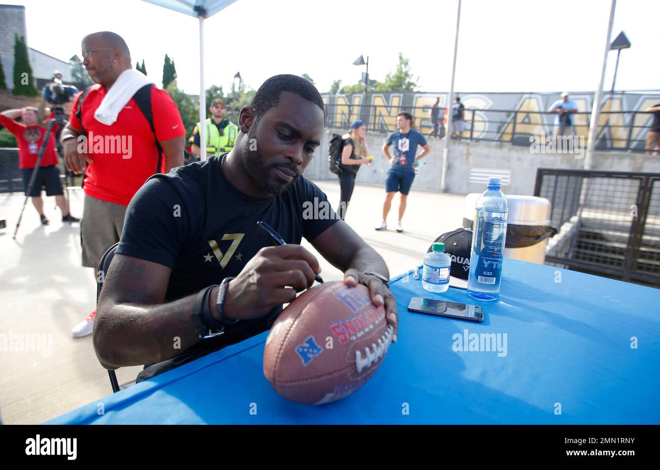 Michael Vick signs autographs before the semifinal round of the ...