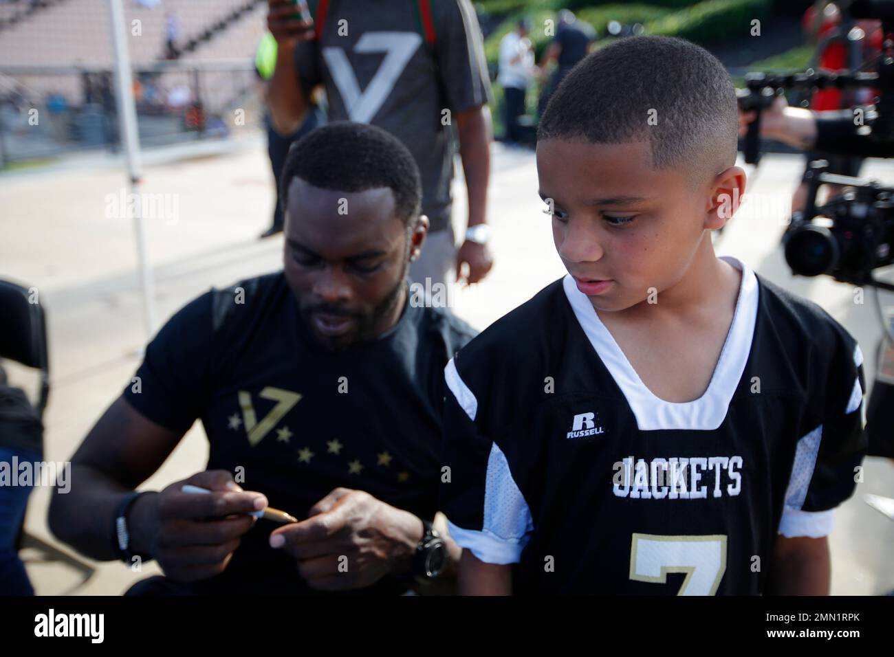 Michael Vick signs autographs before the semifinal round of the ...