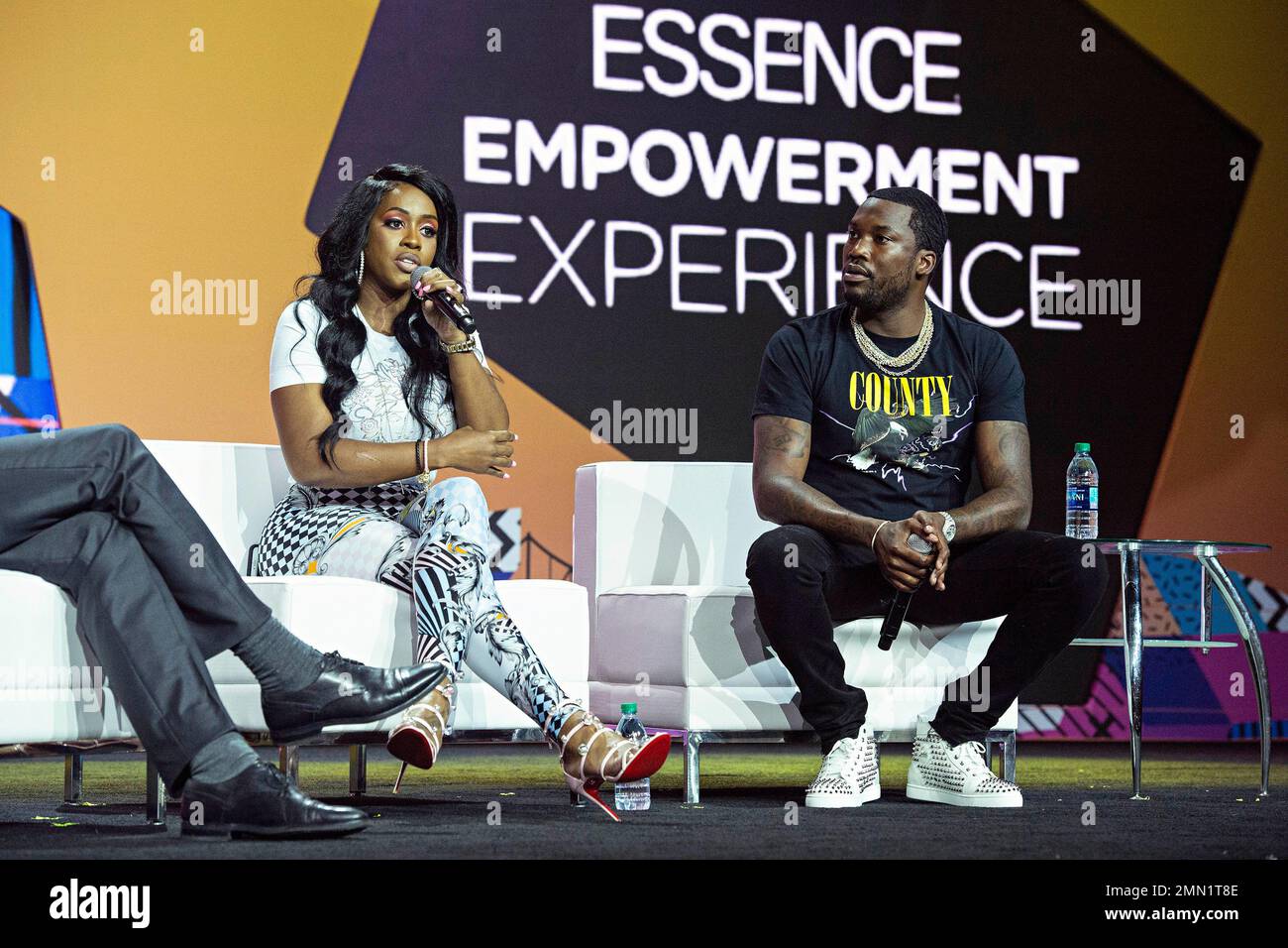 Remy Ma speaks as Meek Mill listens at the 2018 Essence Festival at the ...