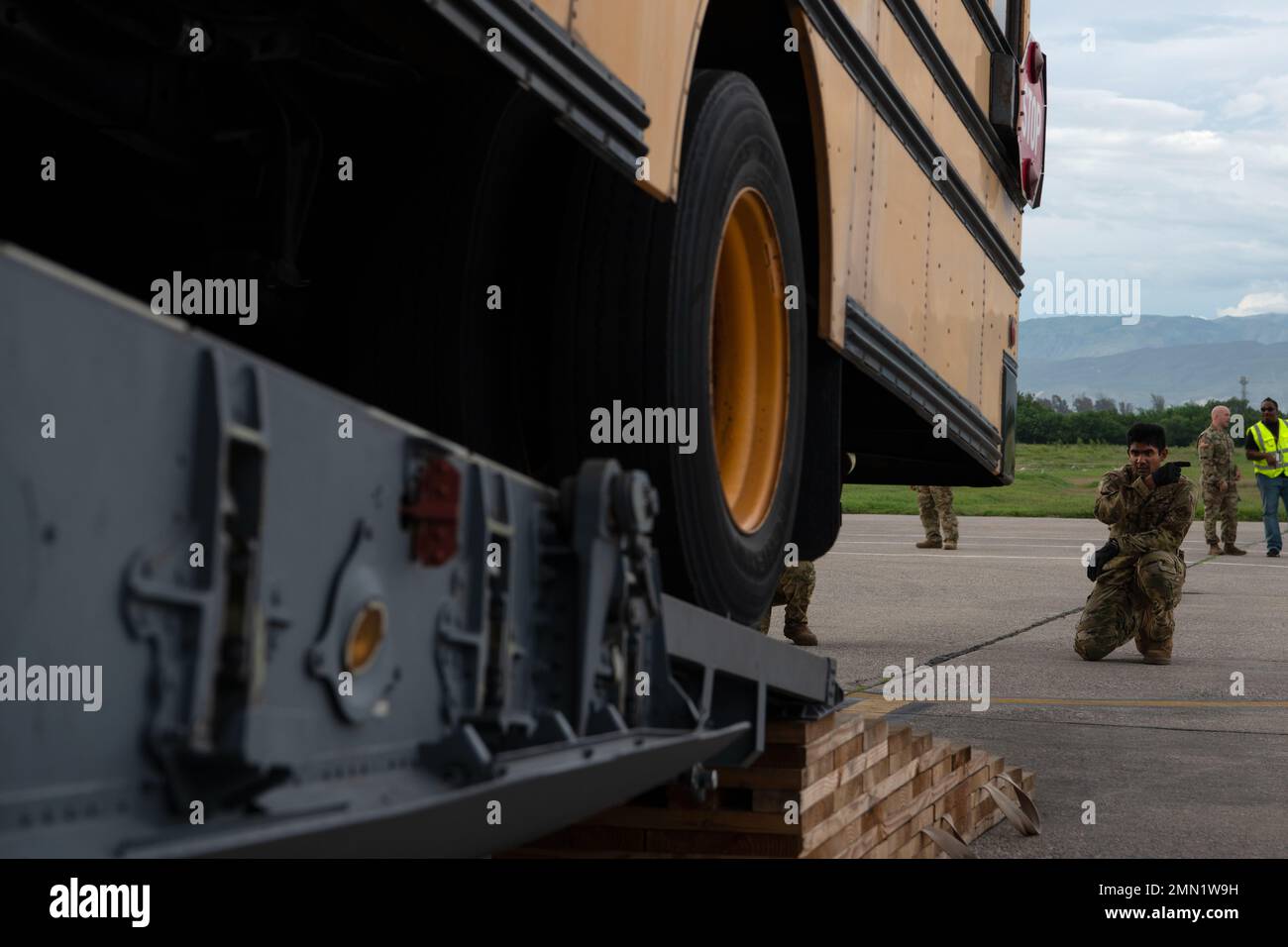 Airman 1st Class Romit Raj, 301st Airlift Squadron, guides a school bus ...
