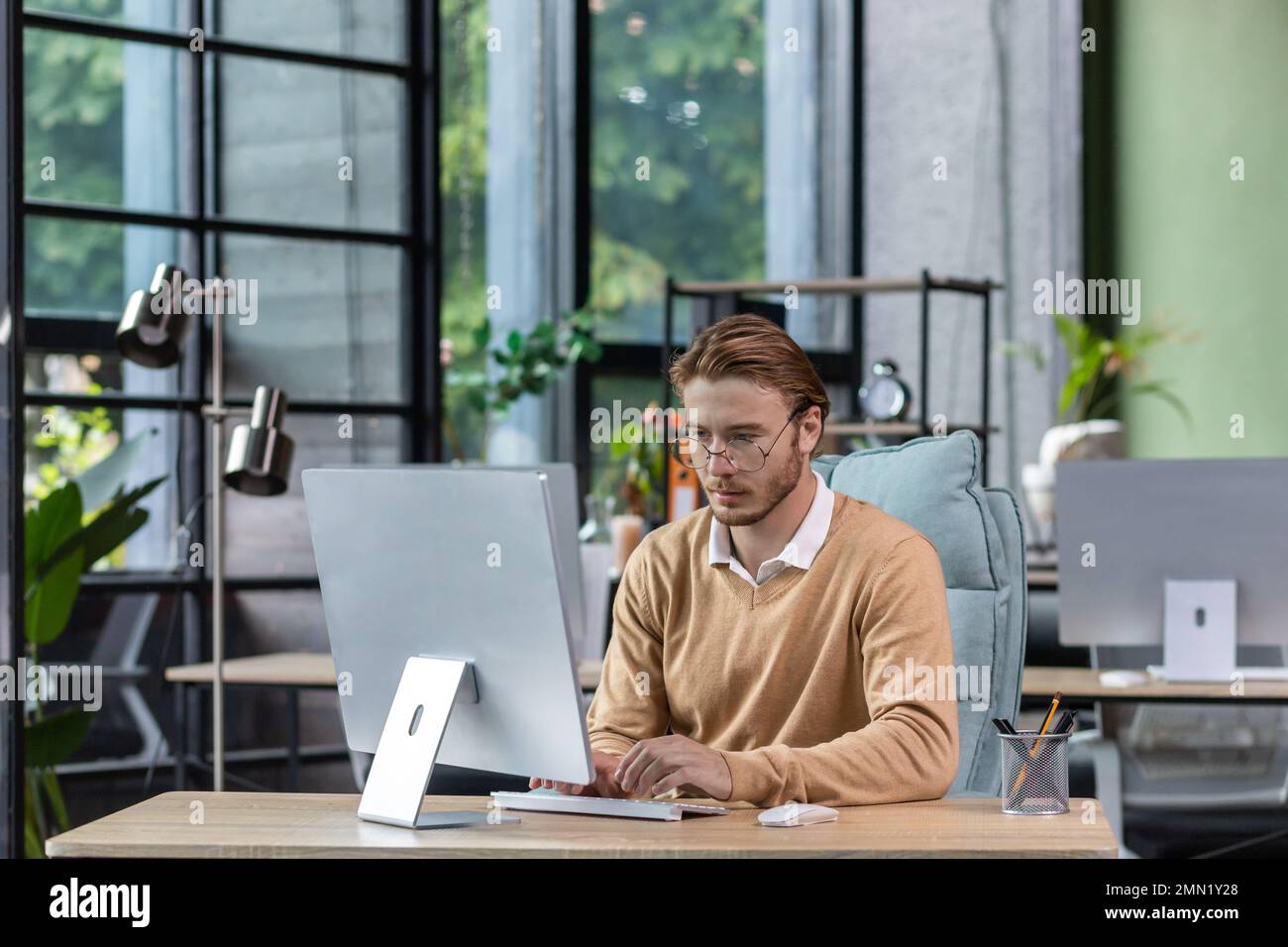 Serious and scorn-centered man in the office at work with a computer ...