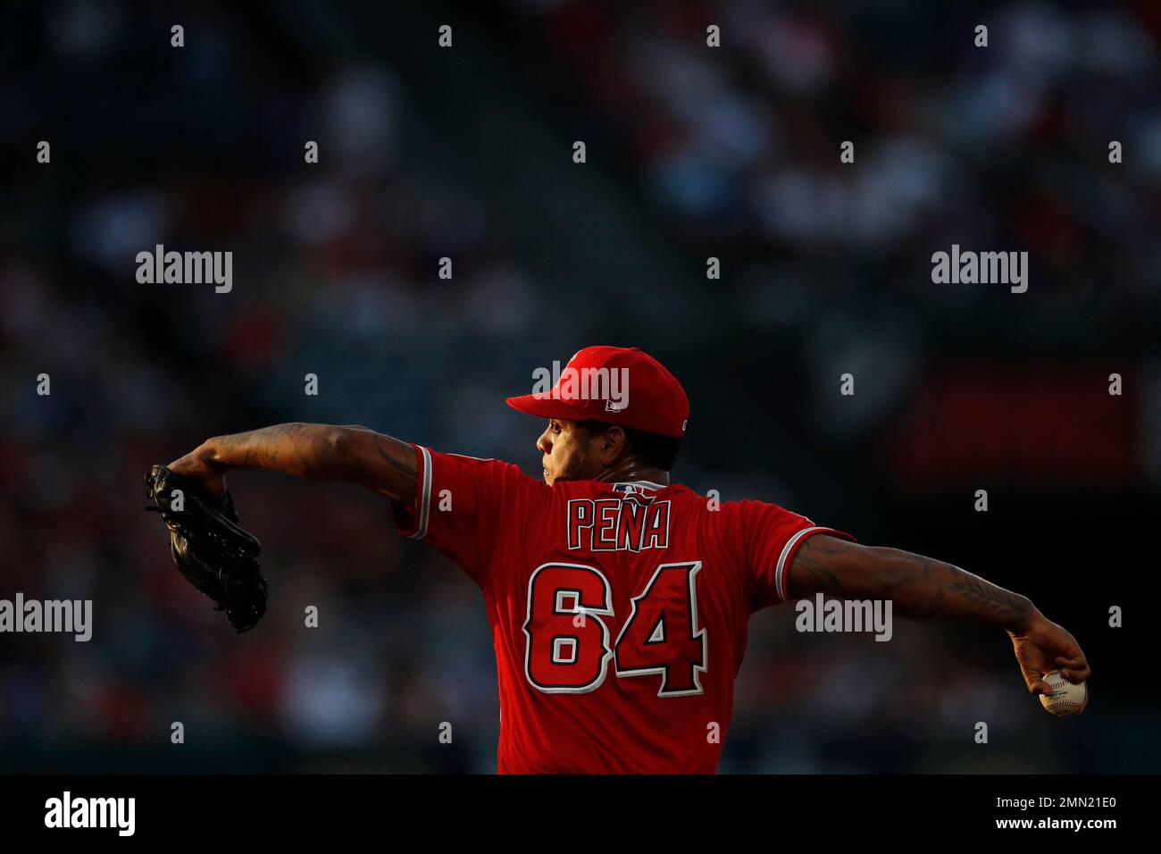 Los Angeles Angels starting pitcher Felix Pena is lit by the setting ...