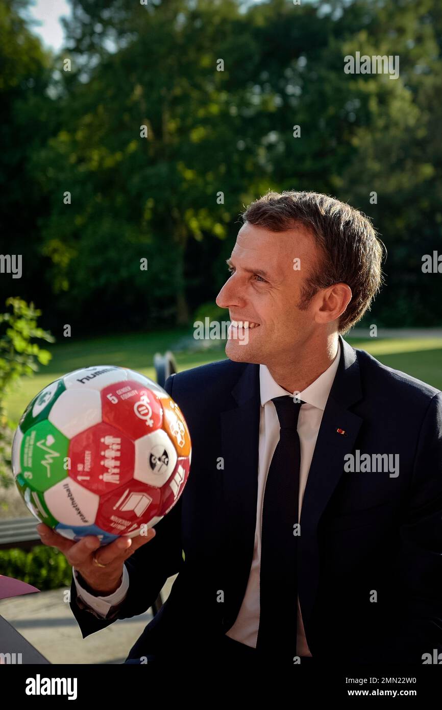 French President Emmanuel Macron holds a soccer ball a gift from Norway ...