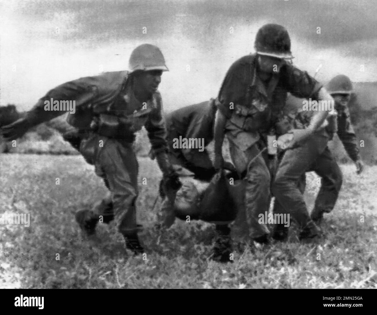 Members of the 101st Airborne Brigade carry a wounded comrade to cover ...