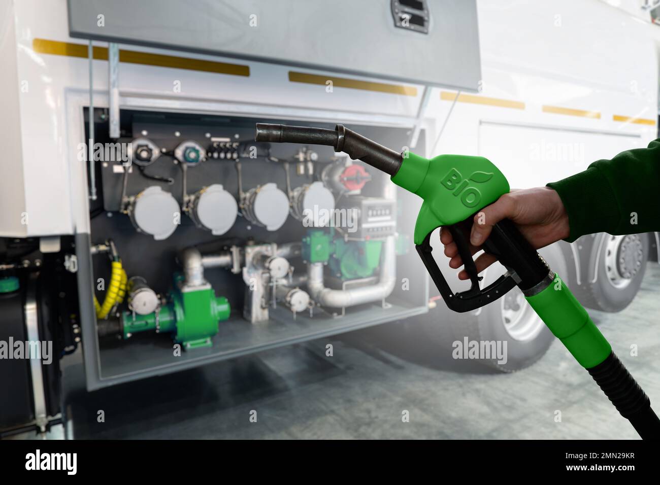 Hand with fuel nozzle with inscription BIO. Carbon neutral bio fuel ...
