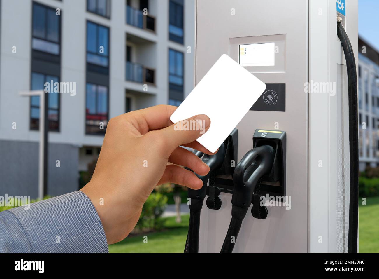 Hand with card on a background of charging station for electric car ...