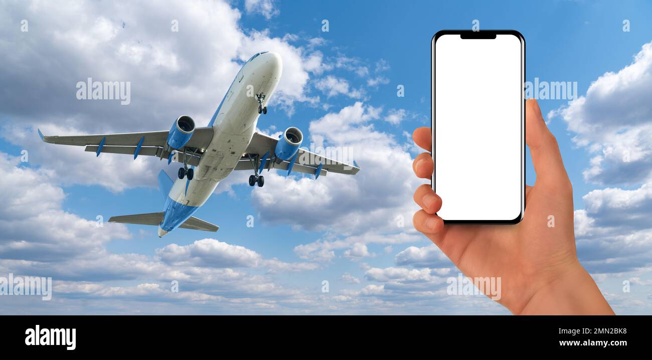 Hand with a phone on the background of an airplane in the sky. White ...