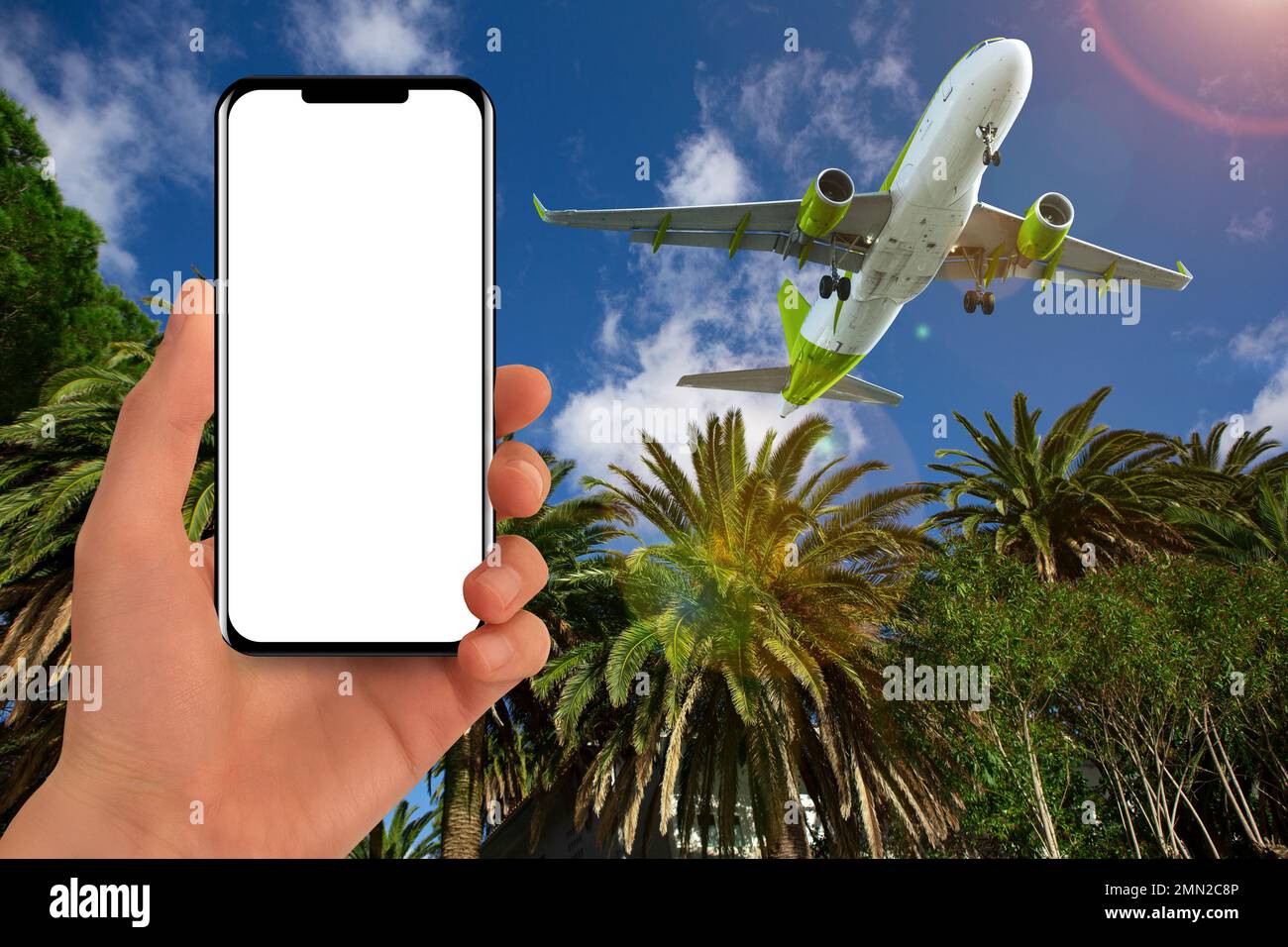 Hand with a phone on the background of an airplane in the sky. White ...
