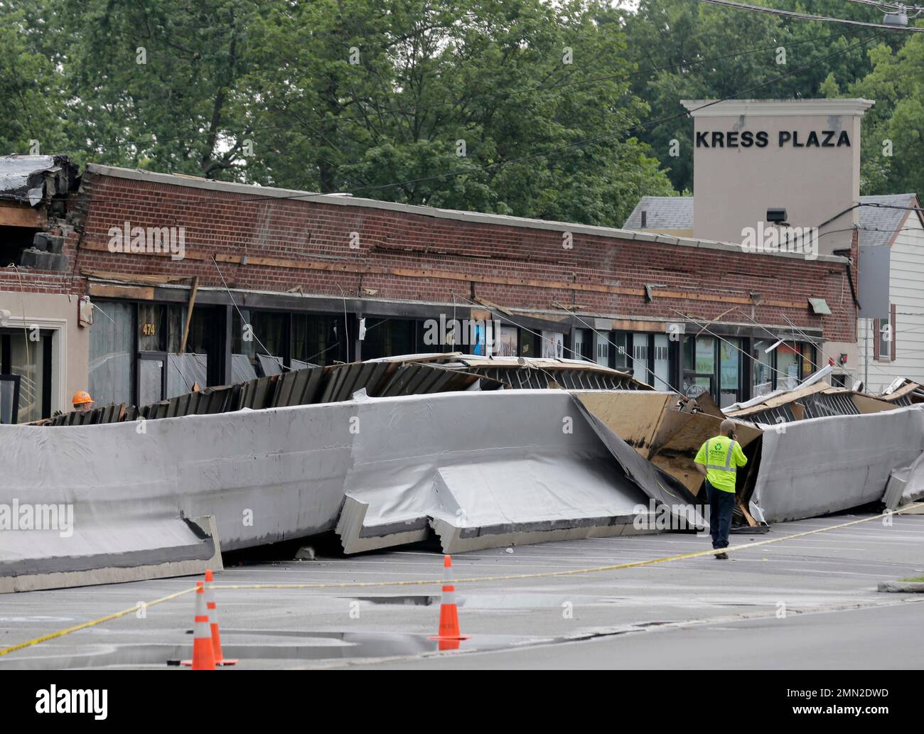 A man walks in front of a strip mall whose facade collapsed in River ...