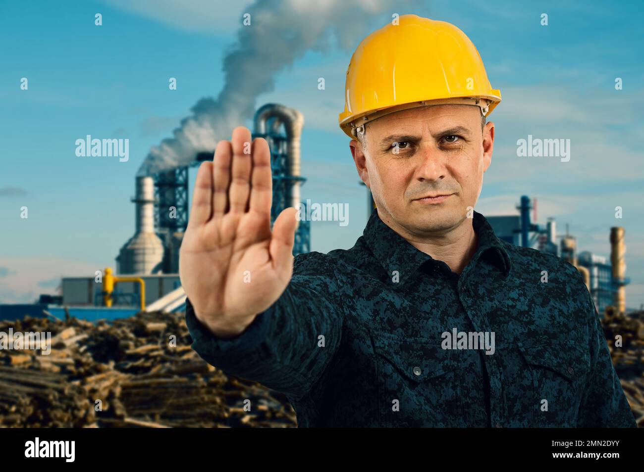 Construction engineer making halt sign in front of a wood processing ...