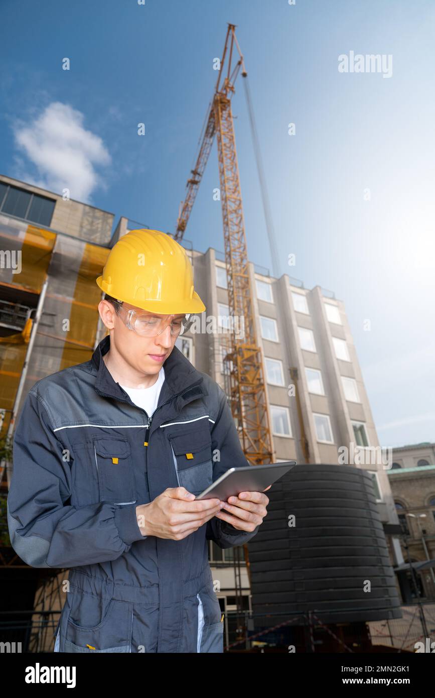 Engineer with a digital tablet on the background of a building under ...