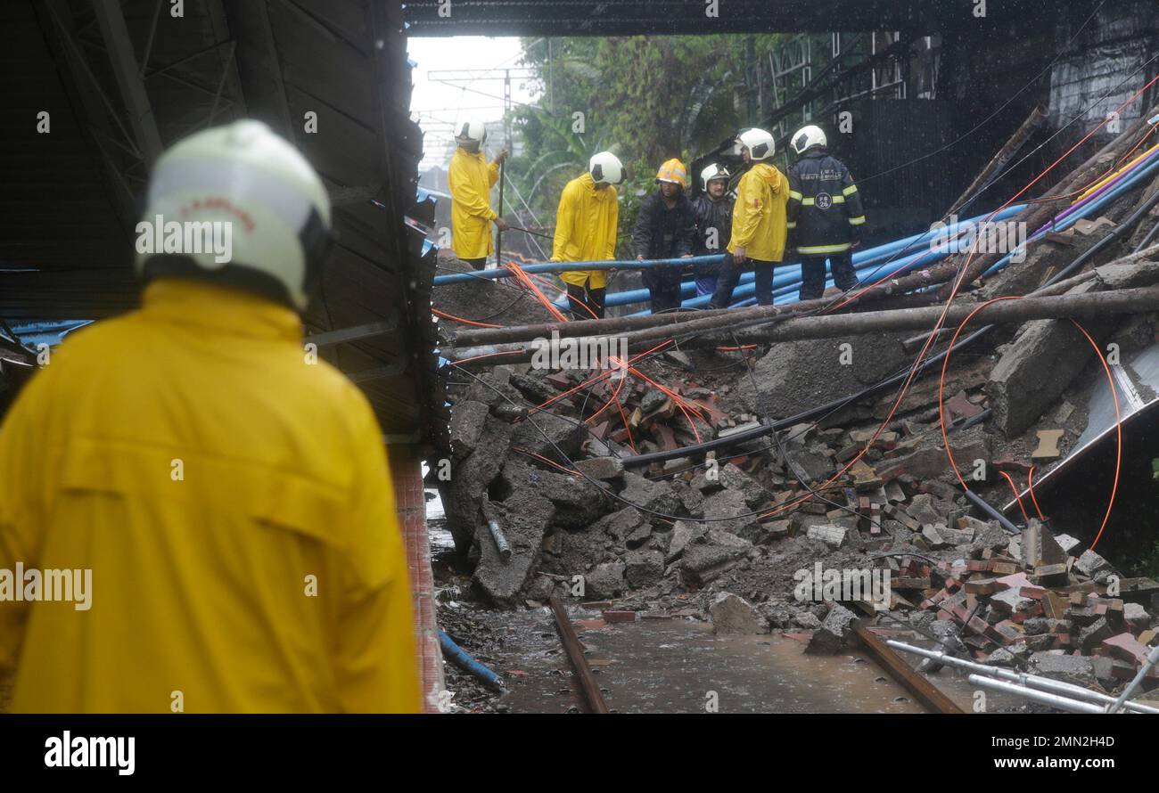 Rescuers work at the site of a pedestrian bridge that collapsed at a ...