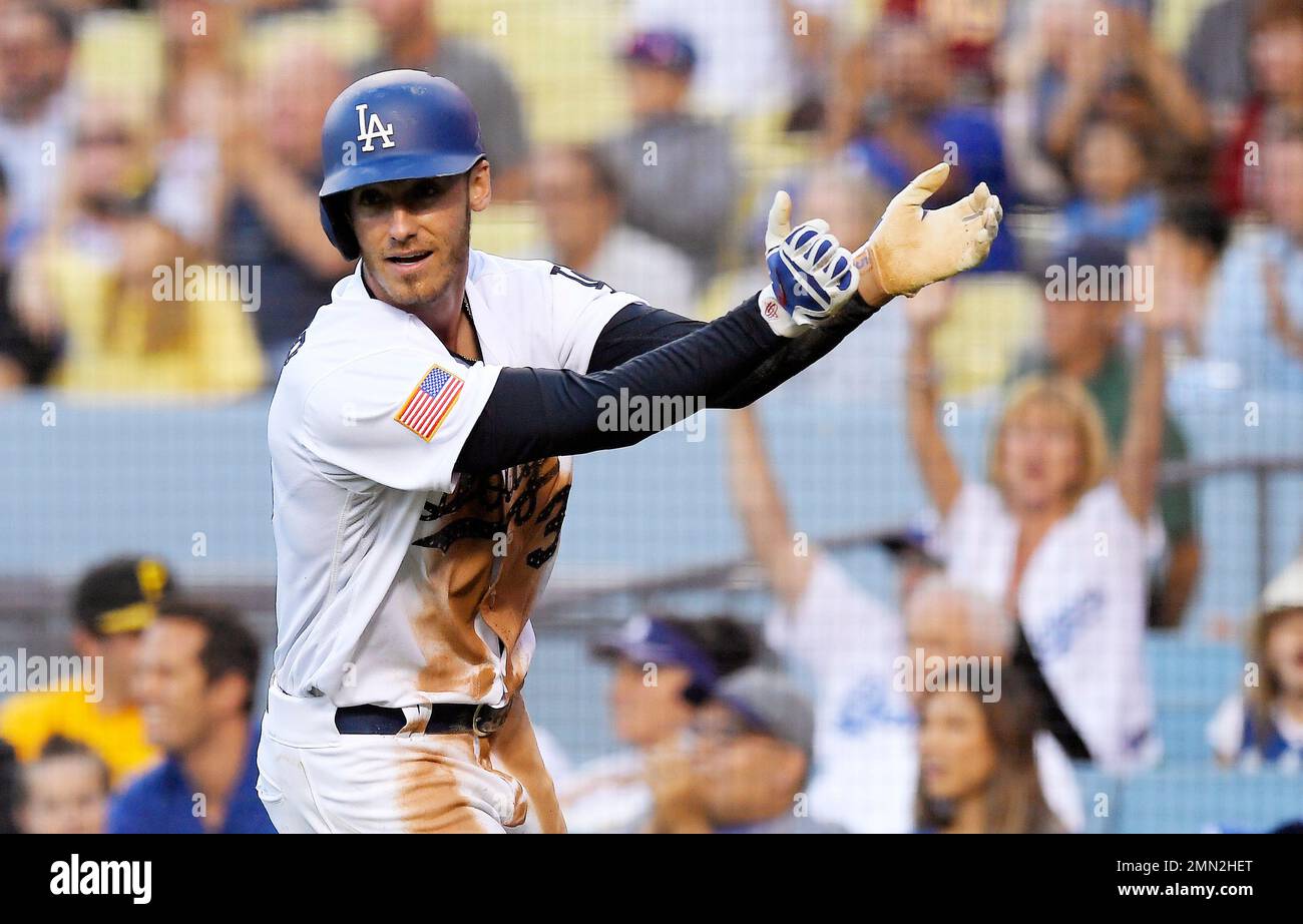 Los Angeles Dodgers' Cody Bellinger claps as he scores on an error by ...