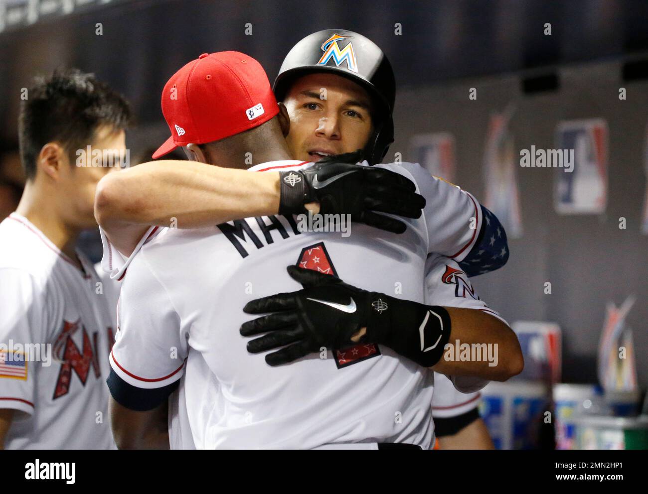Miami Marlins' J.T. Realmuto gets a hug from Cameron Maybin (1) after ...