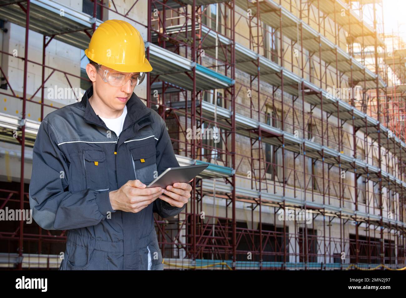 Engineer with a digital tablet on the background of a building under ...
