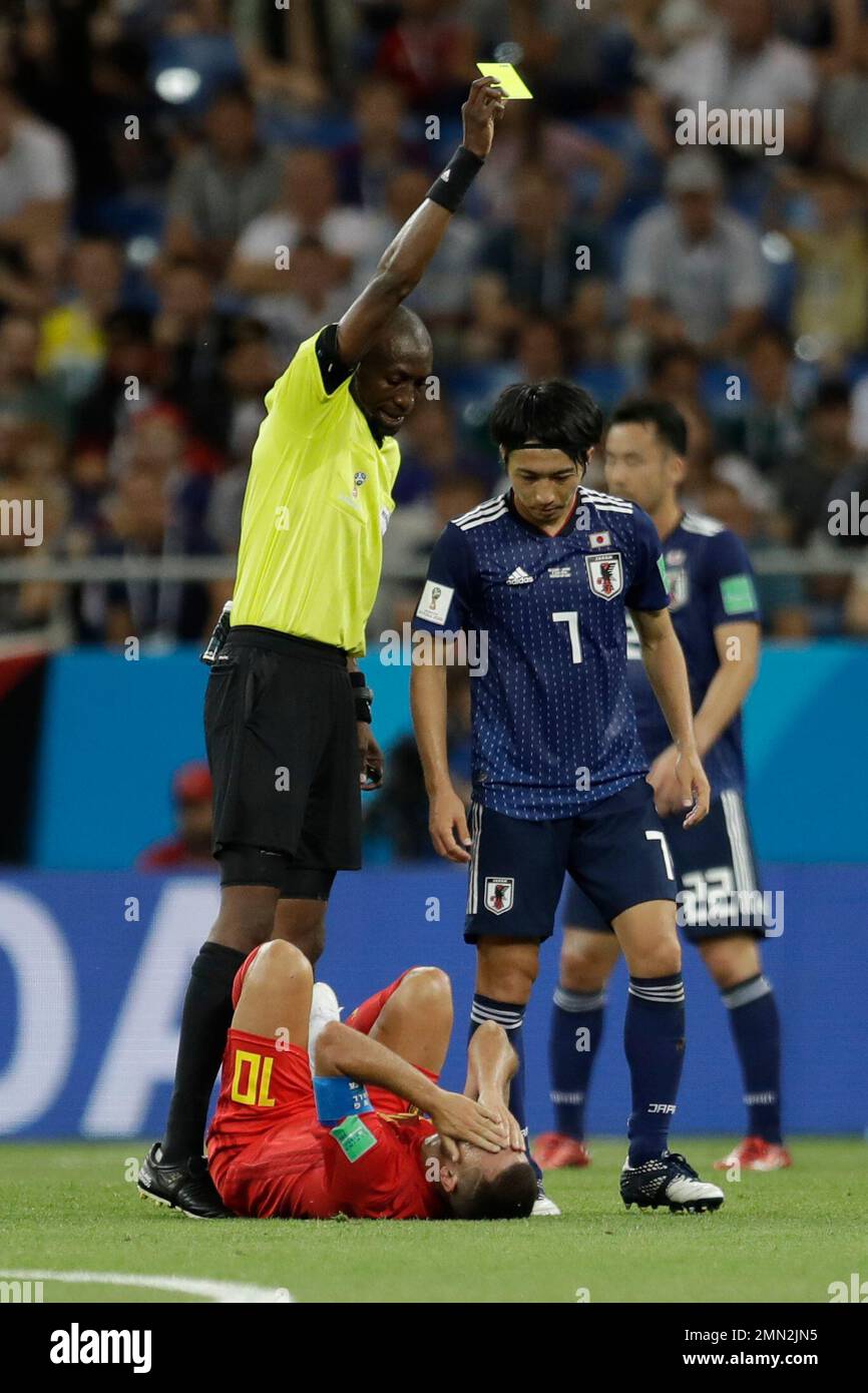 Japan's Gaku Shibasaki, right, is shown a yellow card by Senegal ...