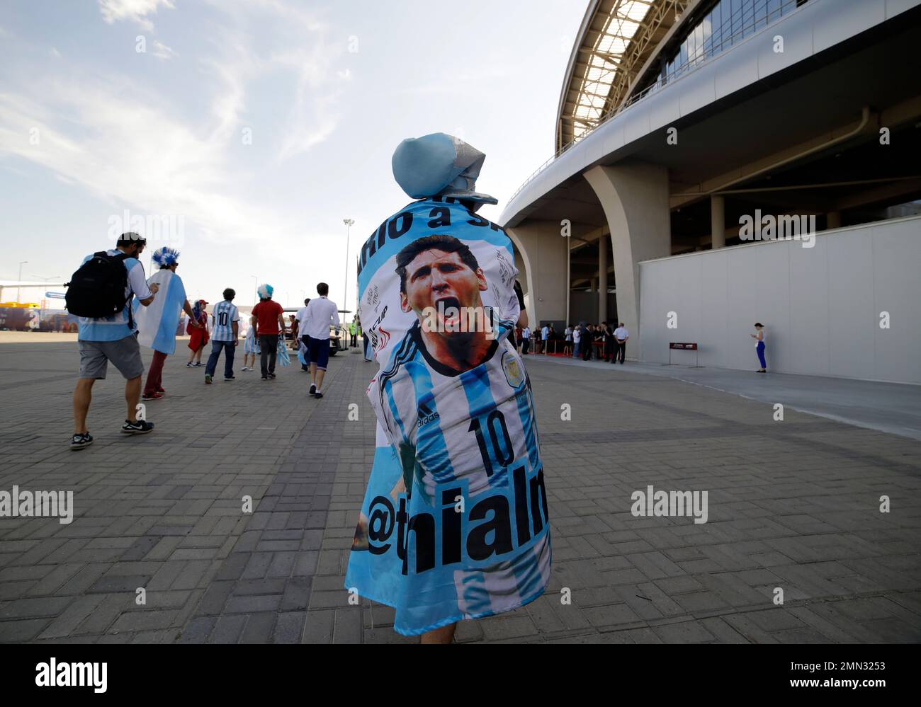 An Argentina fan has an image of Lionel Messi wrapped around his should ...