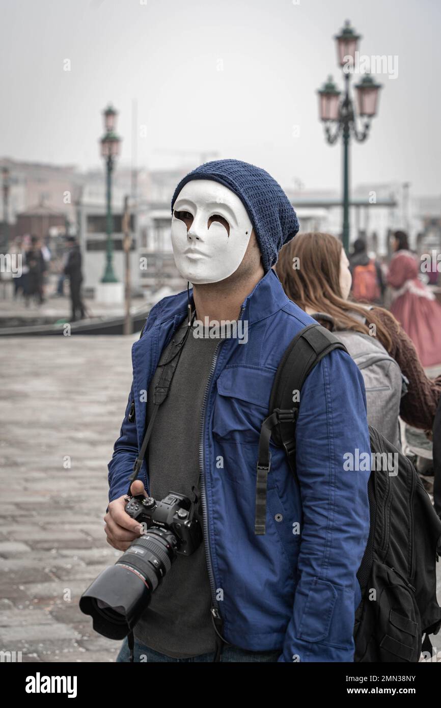 A photographer with a professional camera in mask with Venetian ...
