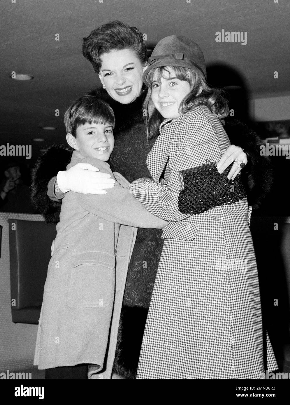 Judy Garland embraces her two children, Joseph, 9, and Lorna Luft, 12, at New York's Kennedy ...