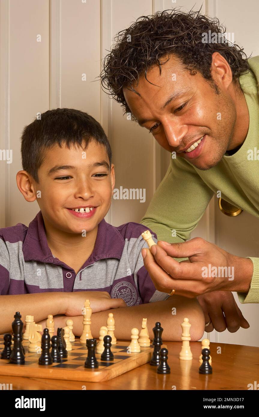 Adult male teaching a young boy how to play chess Stock Photo - Alamy