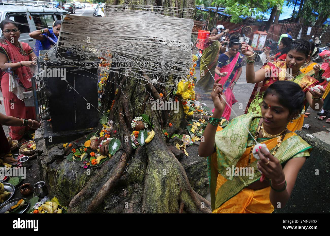 Indian Hindu married women perform rituals around a Banyan tree on the ...