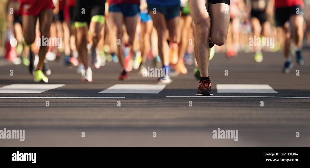 Marathon runners running on city road, large group of runners Stock ...