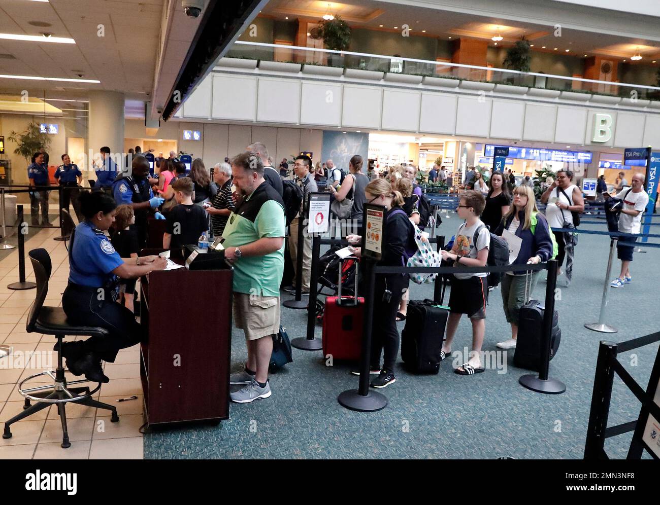 Air passengers heading to their departure gates enter TSA precheck ...