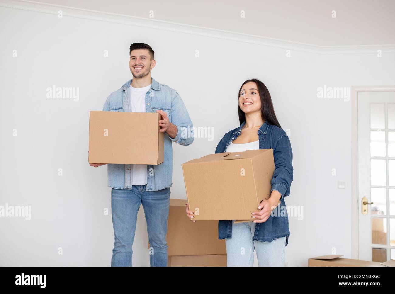 Relocation Concept. Happy Young Spouses Walking With Cardboard Boxes In ...