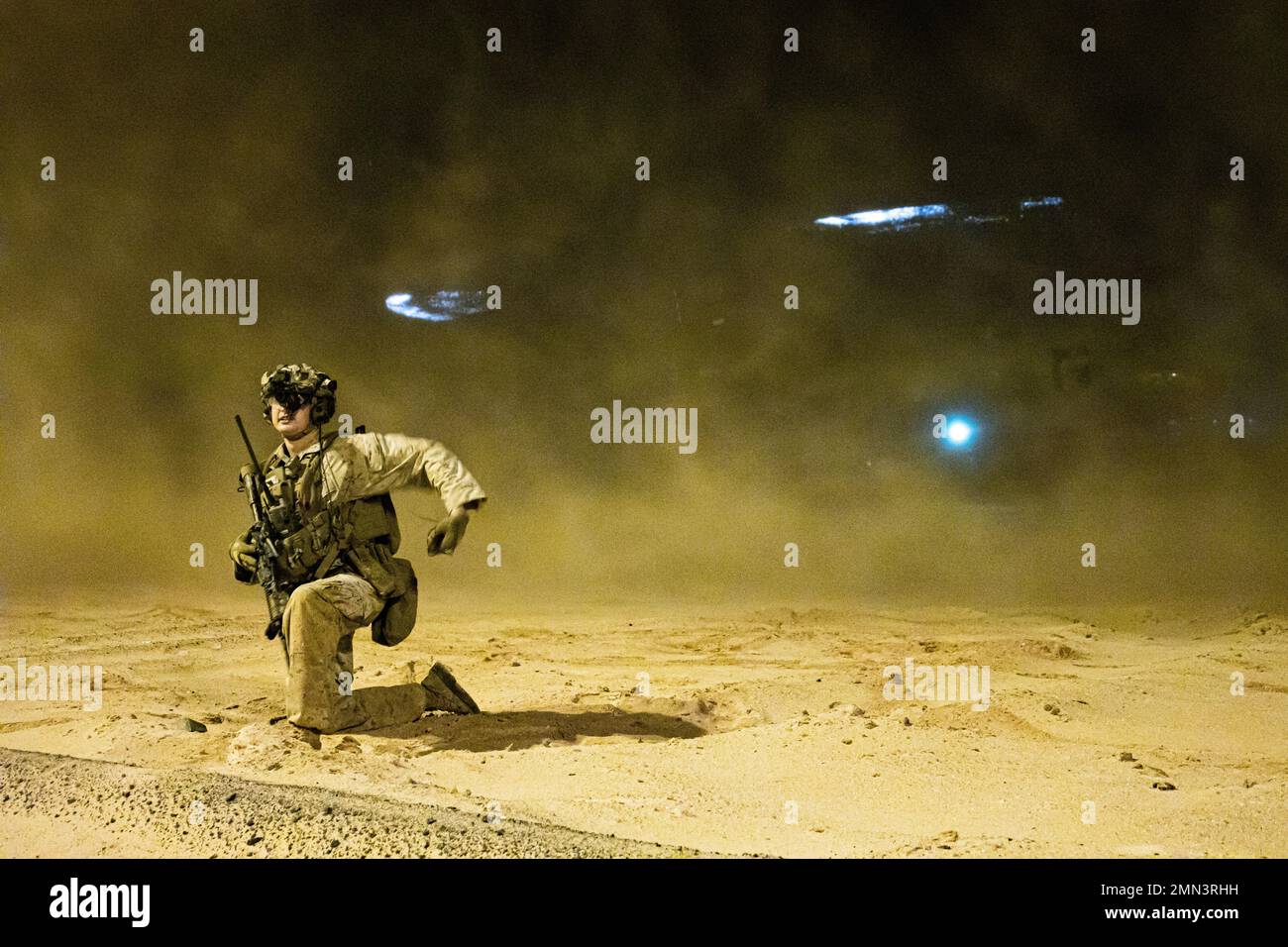 A U.S. Marine with India Company, 3rd Battalion, 5th Marine Regiment, guides in a CH-57 Chinook ...