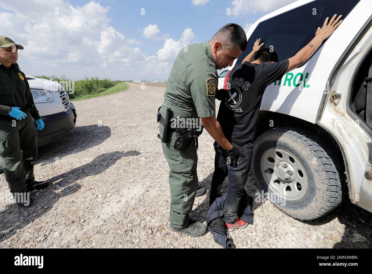 U.S. Border Patrol agent Rene Cisneros gives migrant Gerberht Caraac ...
