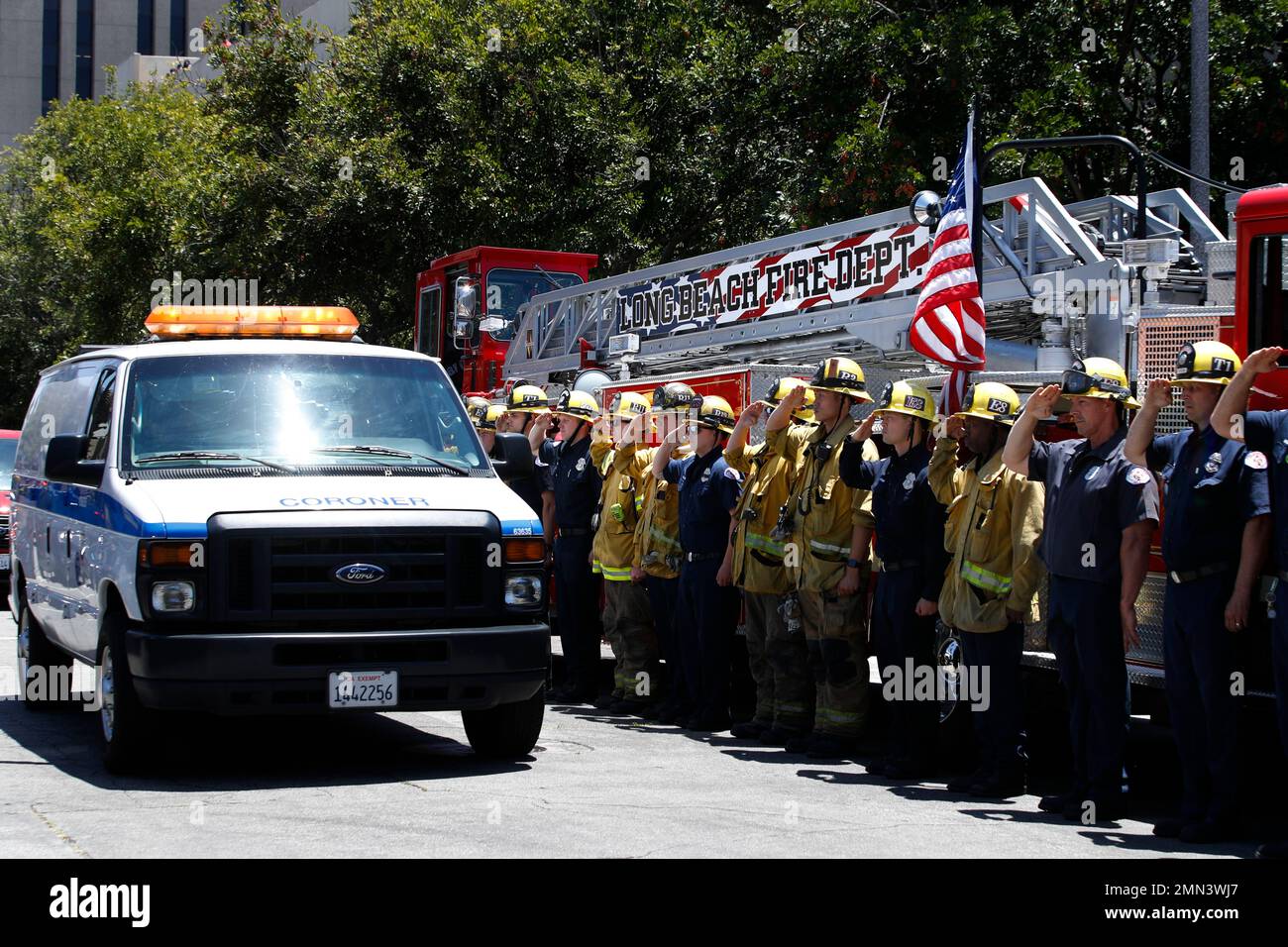 Firefighters salute as a van carrying the body of Long Beach Fire Capt ...