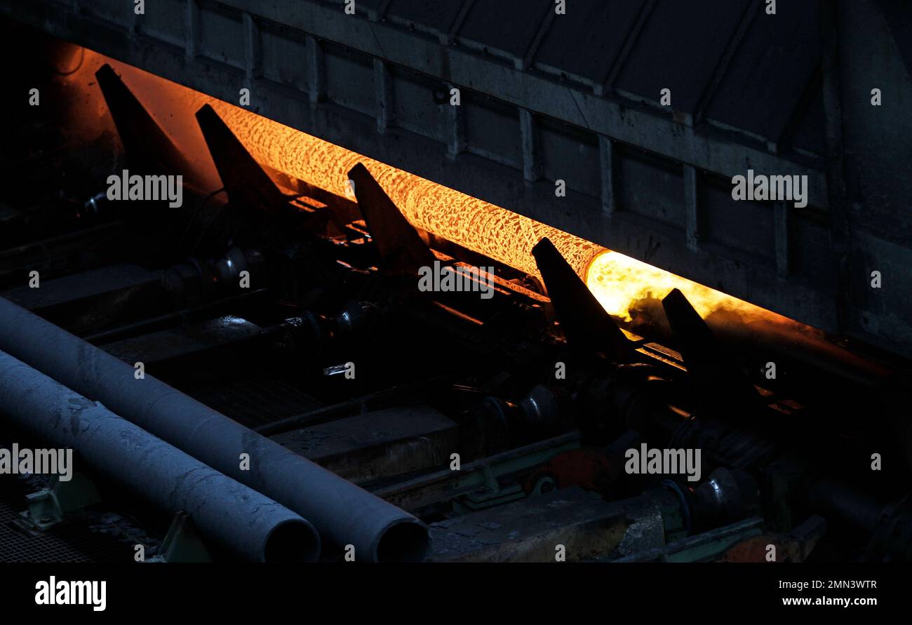 A steel billet is pierced during the hot rolling process to create a ...