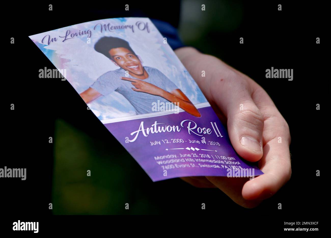 Kyle Fogarty shows a memorial card after leaving the funeral for Antwon ...