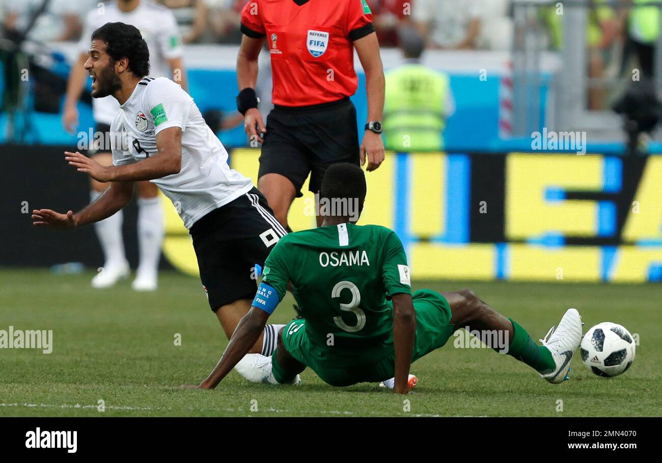 Egypt's Marwan Mohsen falls beside Saudi Arabia's Osama Hawsawi during ...