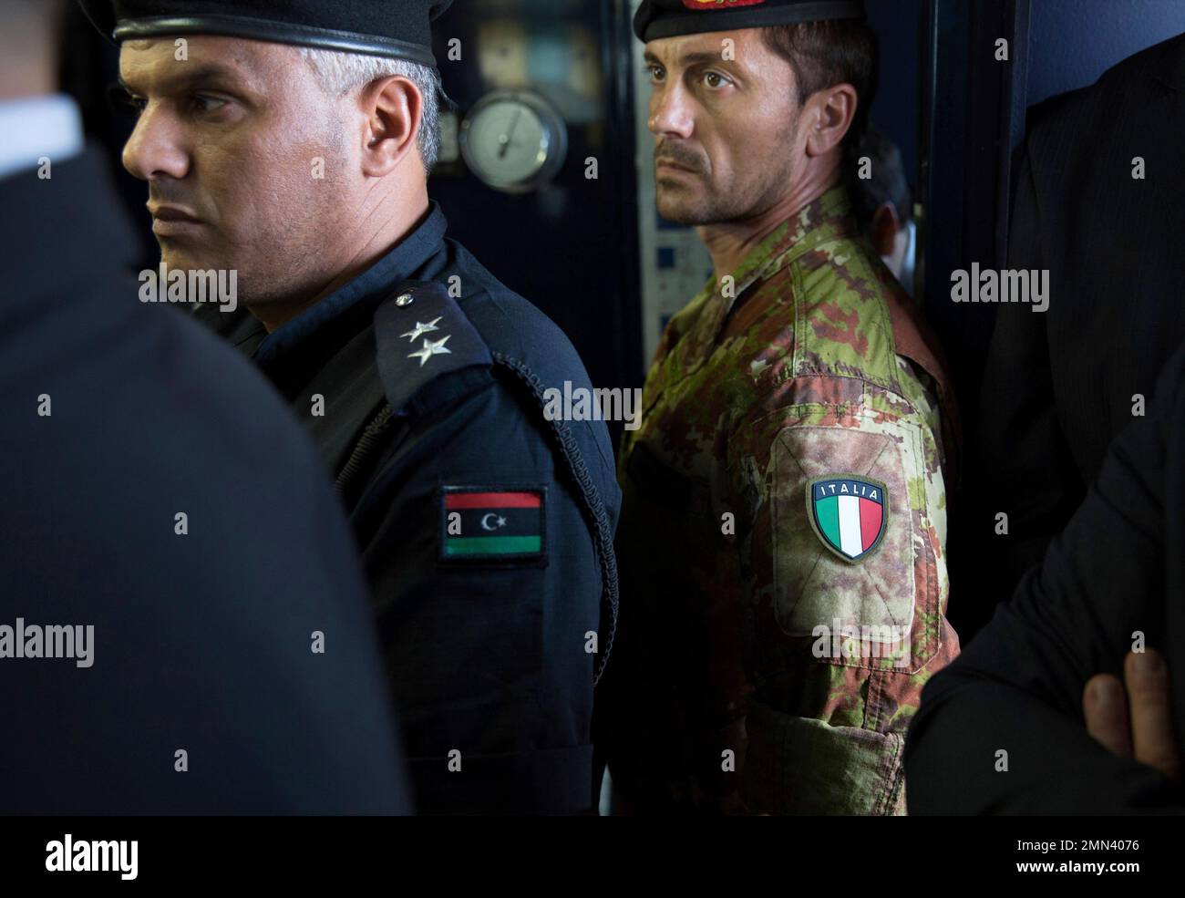 A member of the Italian naval forces, right, stands with a Libyan ...