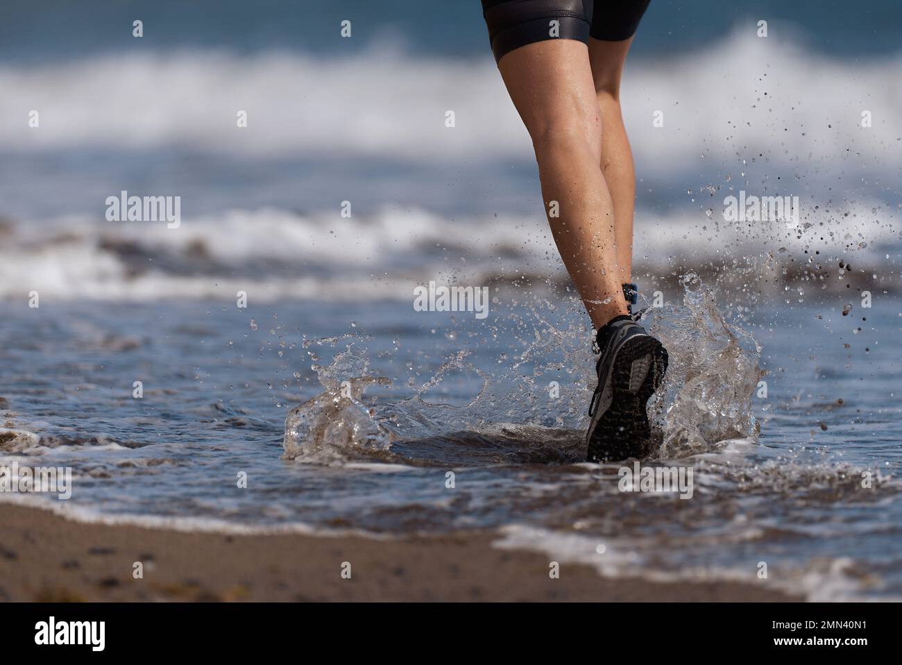 Athlete runner running on waves of sea beach Stock Photo - Alamy