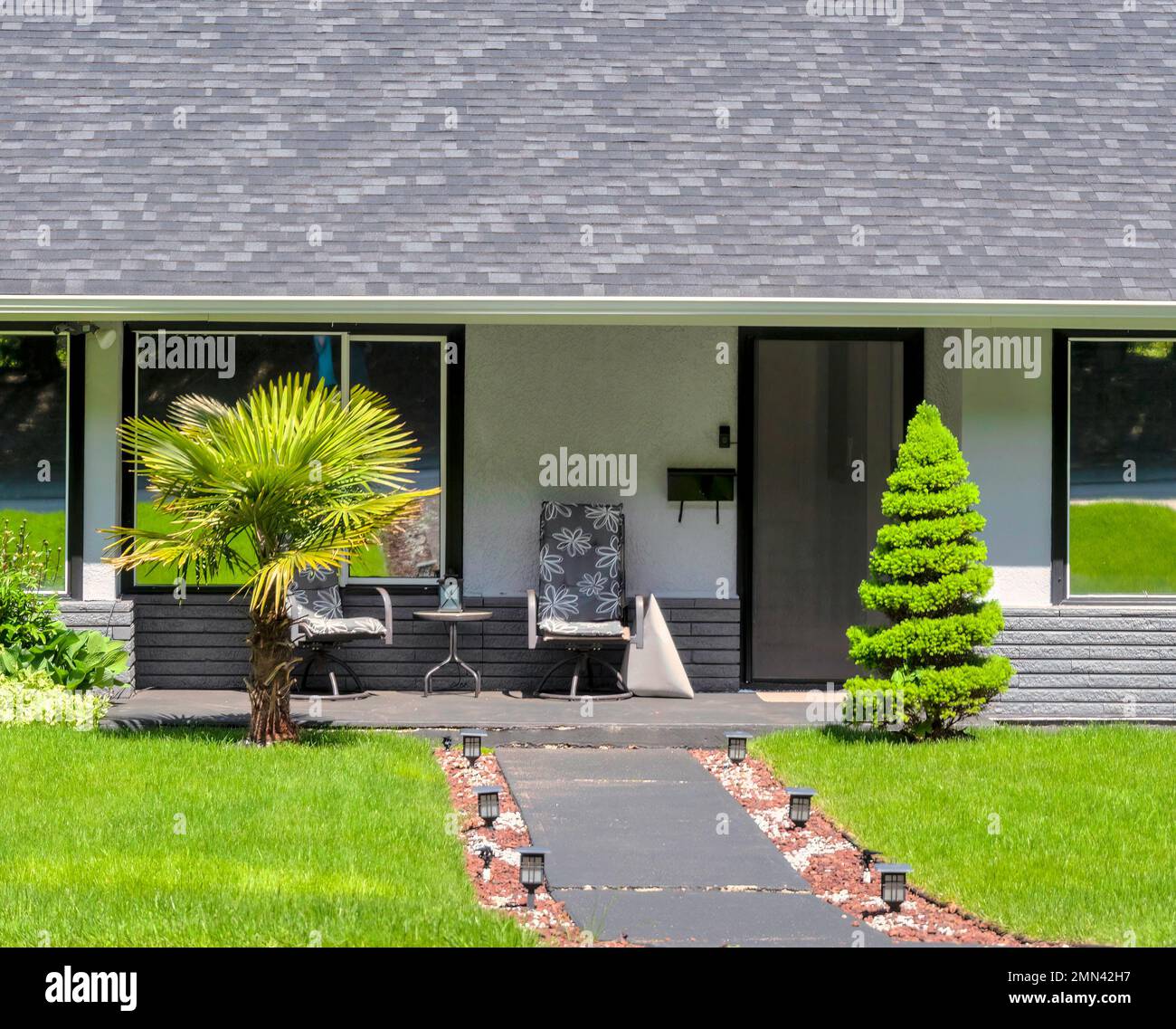 Main entrance of residential house with concrete pathway on bright ...