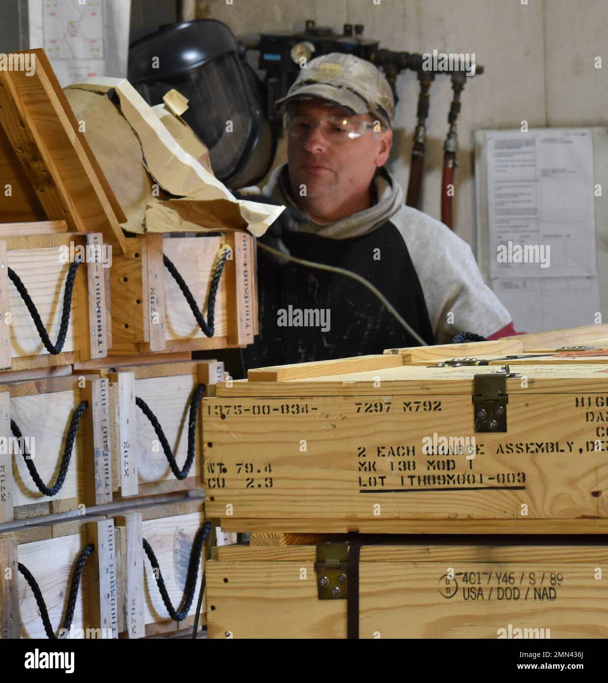 A Crane Army explosives handler works to build charges to be detonated ...