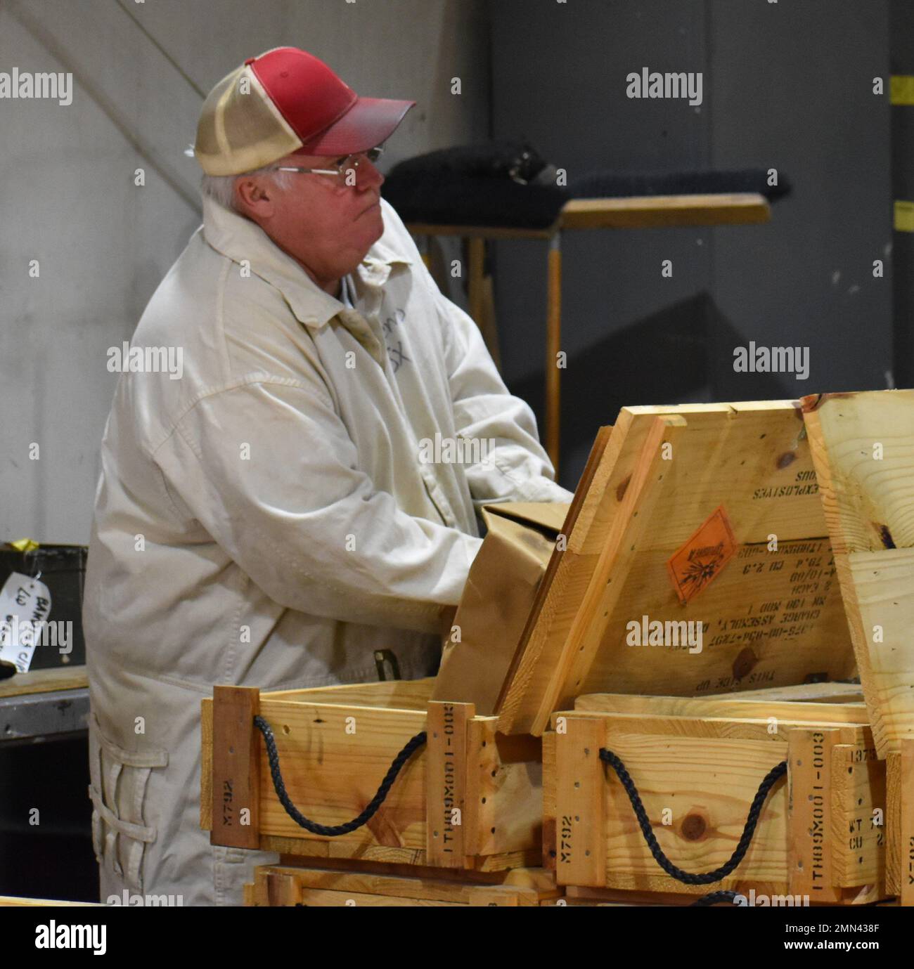 A Crane Army explosives handler works to build charges to be detonated ...