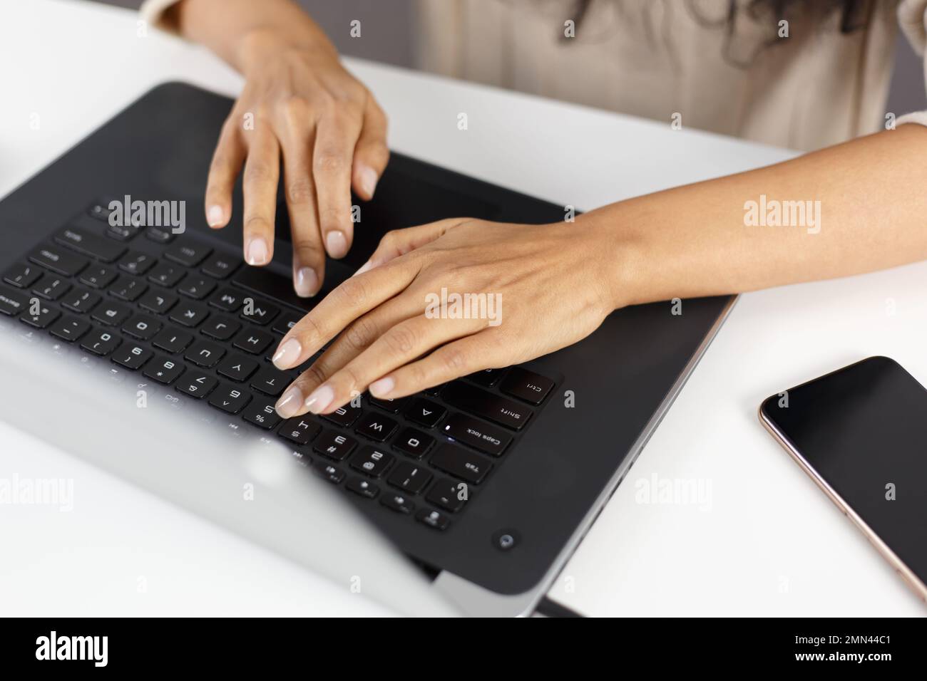 BIPOC programmer coding on computer at home. Overhead phoot of POC ...