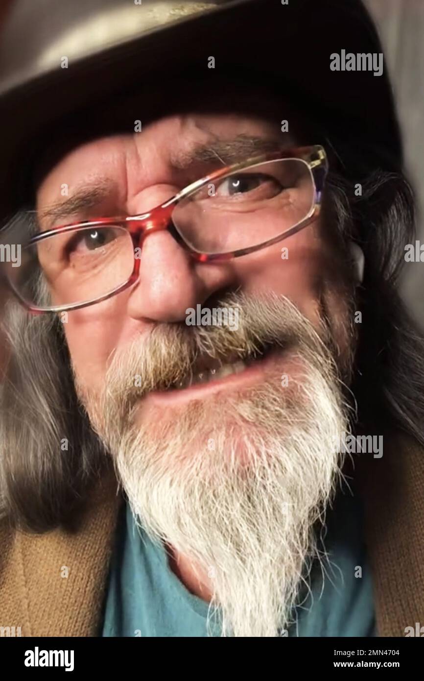 Elderly person with long beard and vintage hat poses for a portrait ...