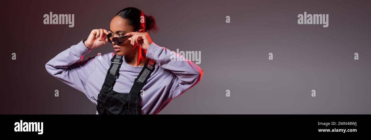 african american woman in sweatshirt wearing sunglasses on grey ...