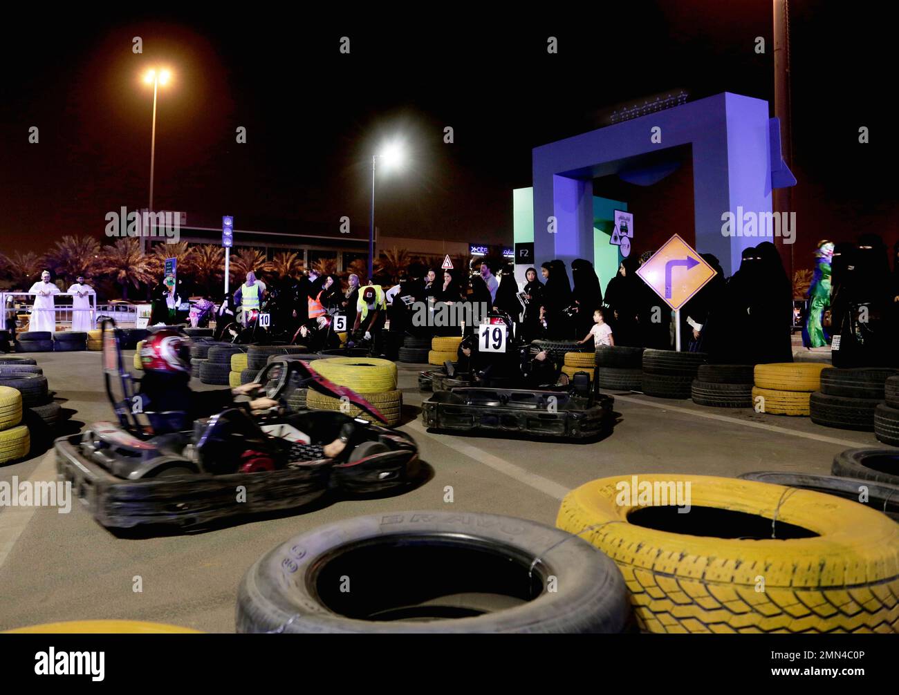 In this June 22, 2018 photo, women wait in line to ride go carts at a ...